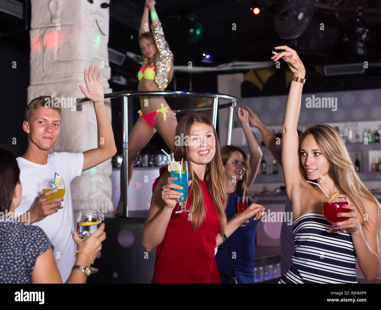 Group of laughing people clubbing in the night club with drink Stock ...
