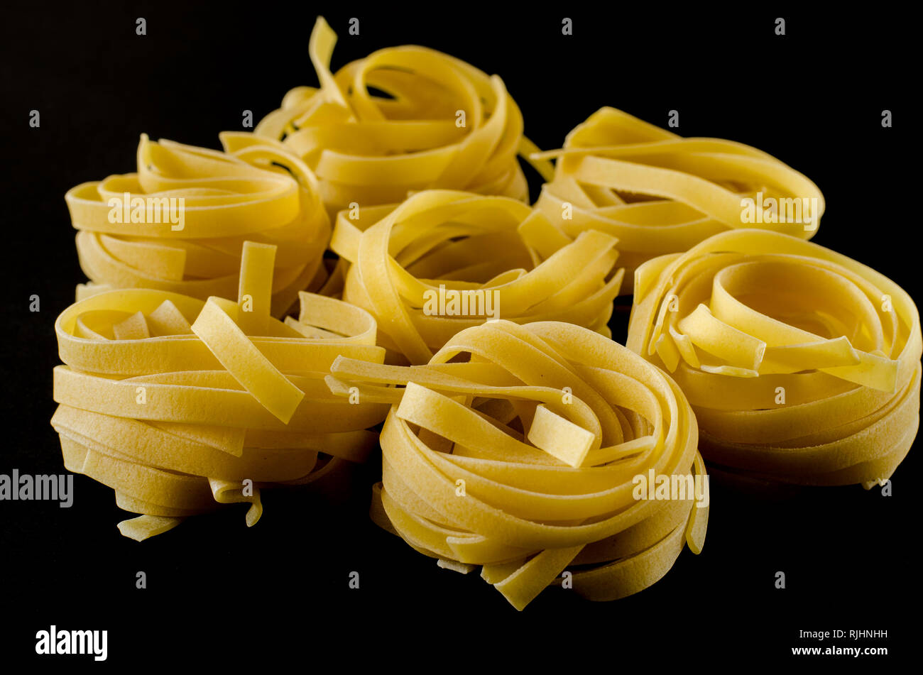 Round balls of raw pasta on black background Stock Photo - Alamy