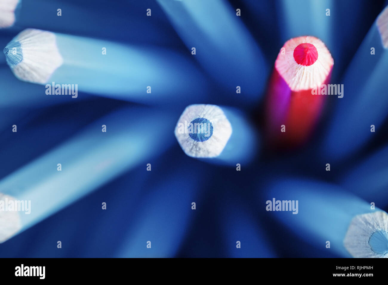 One red pencil among of blue toned group Stock Photo - Alamy