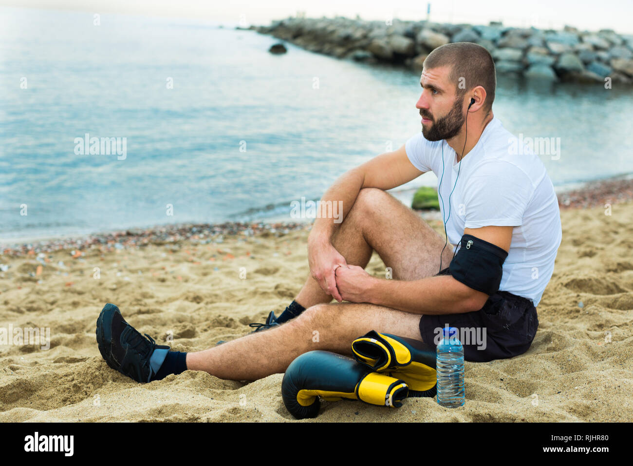 Athletic man resting after strenuous training on the seashore Stock ...
