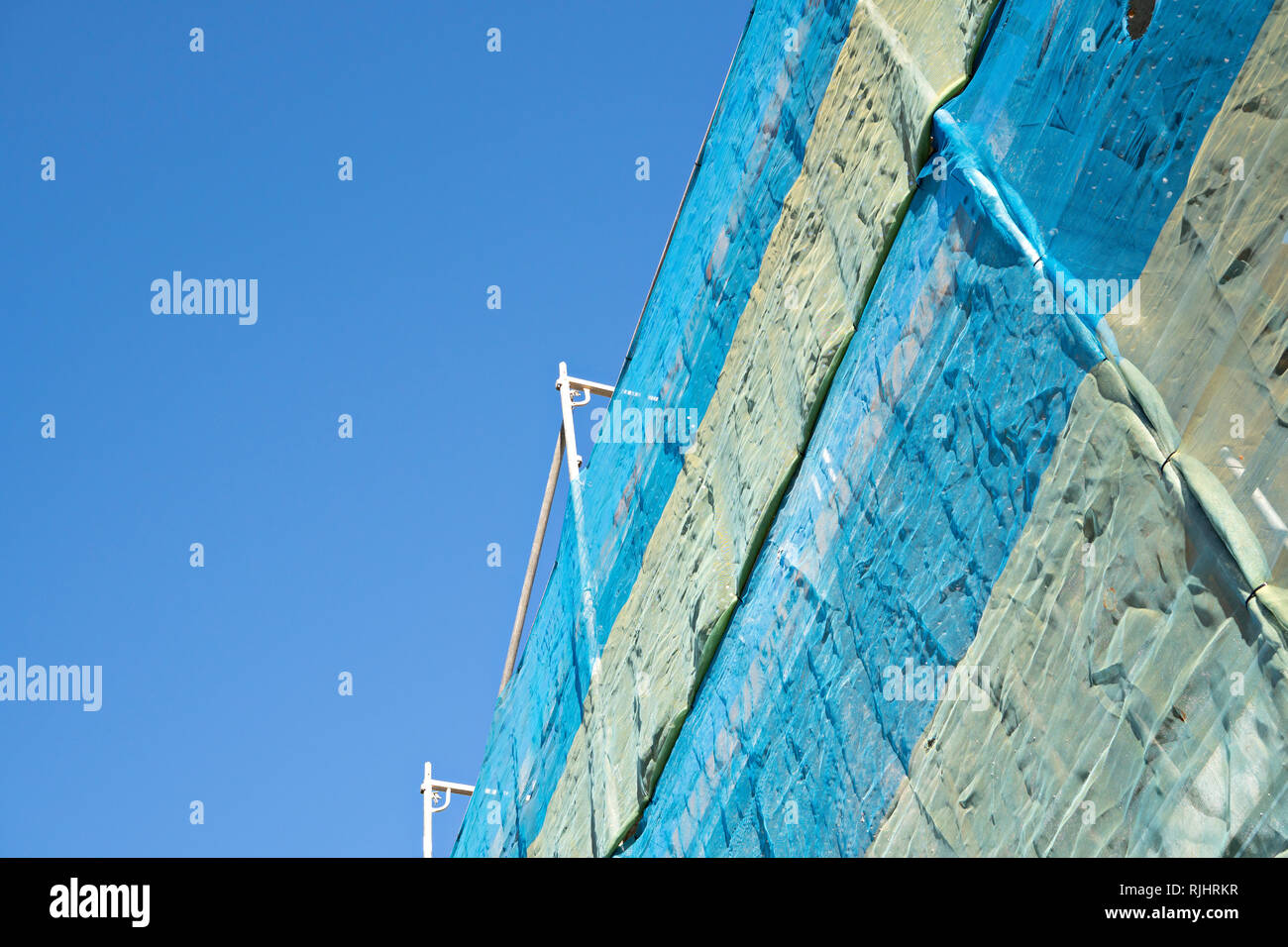 Scaffold with netting protection on building under construction against ...