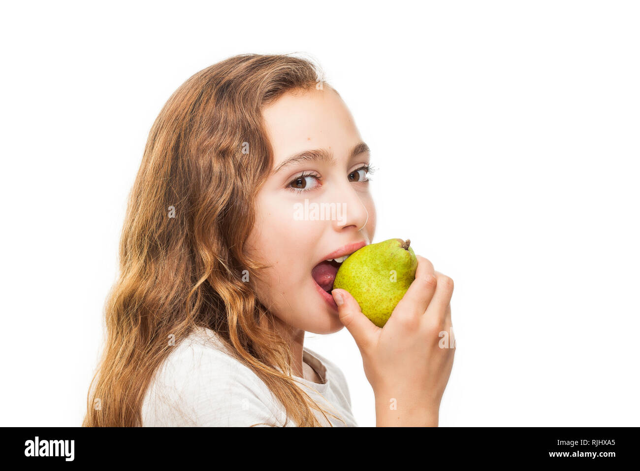 Young girl eating fruit isolated on white background Stock Photo - Alamy