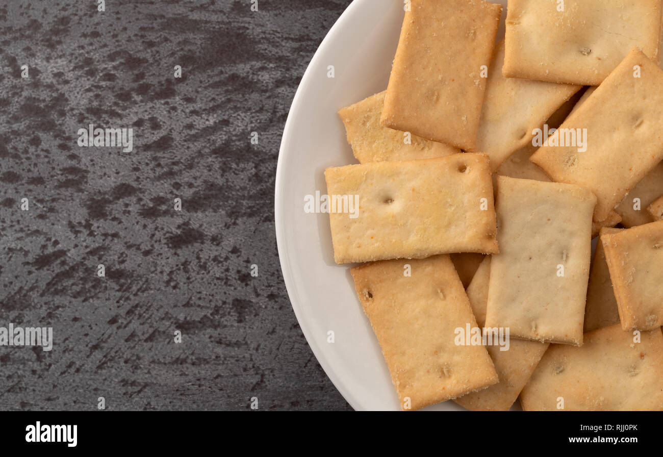Top close view of cheese flavor crostini crackers on a white plate atop ...
