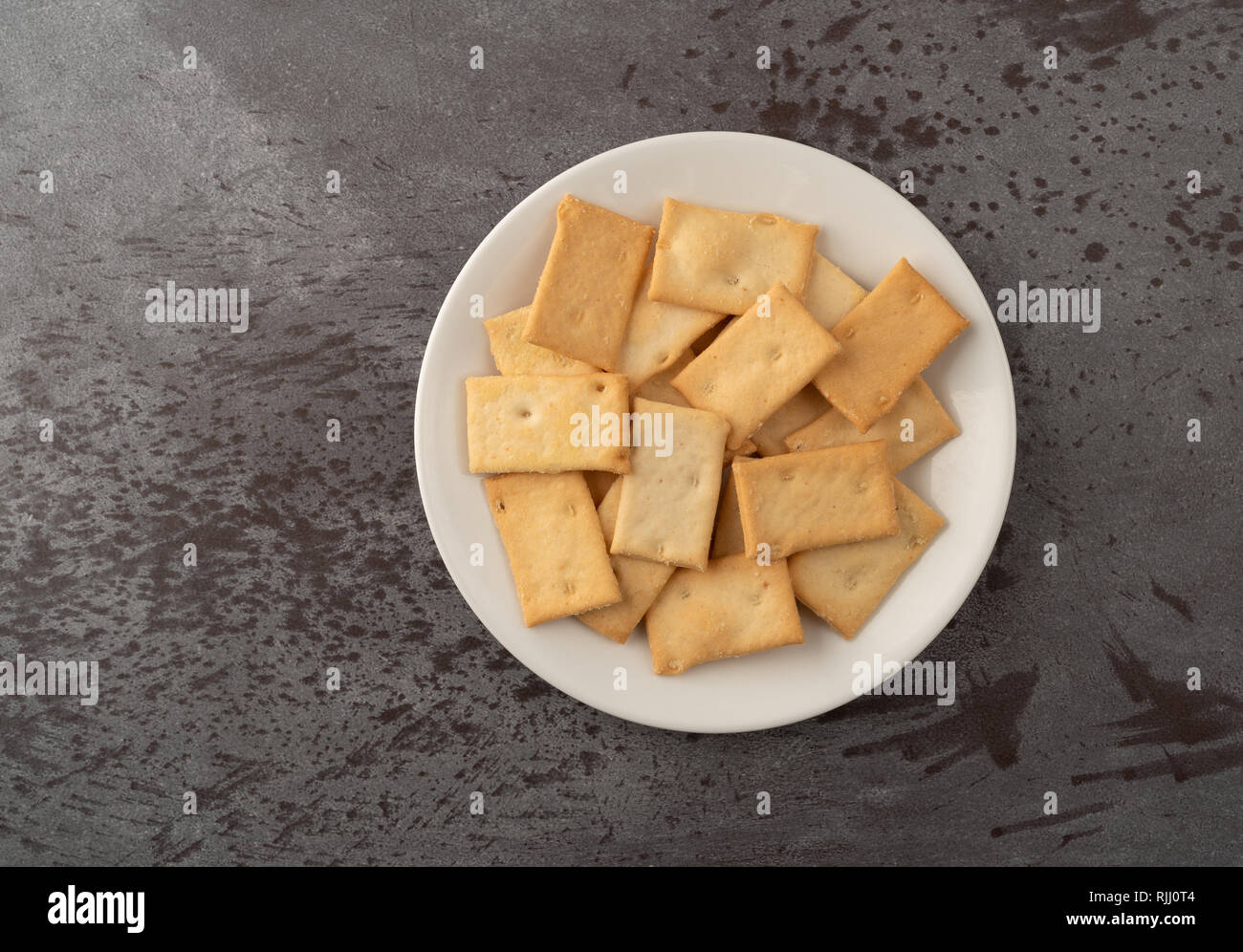 Overhead view of cheese flavor crostini crackers on a white plate atop ...