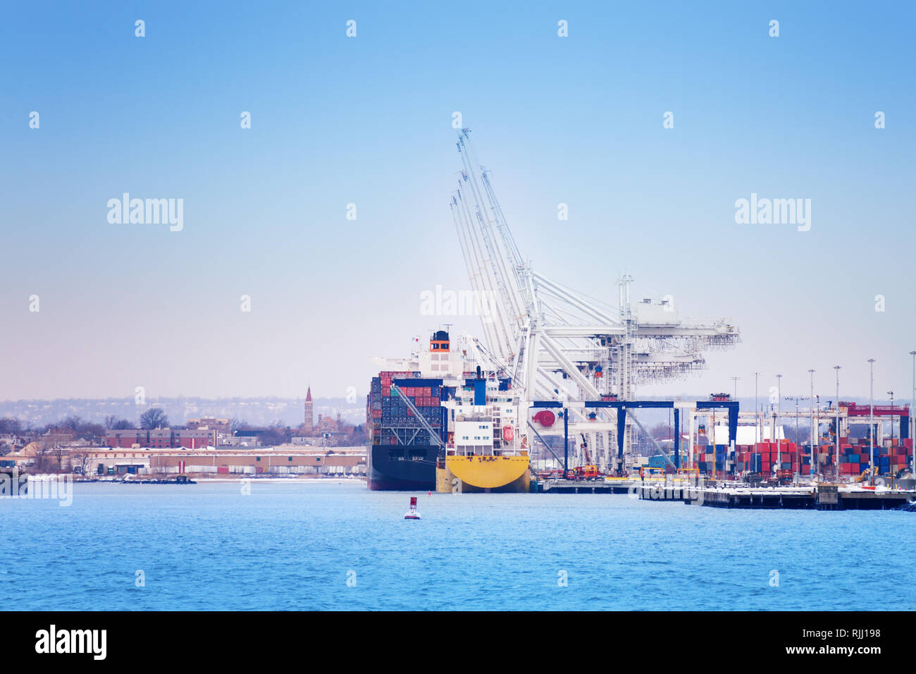 Marine cranes loading containers on cargo ship at dockside of maritime ...