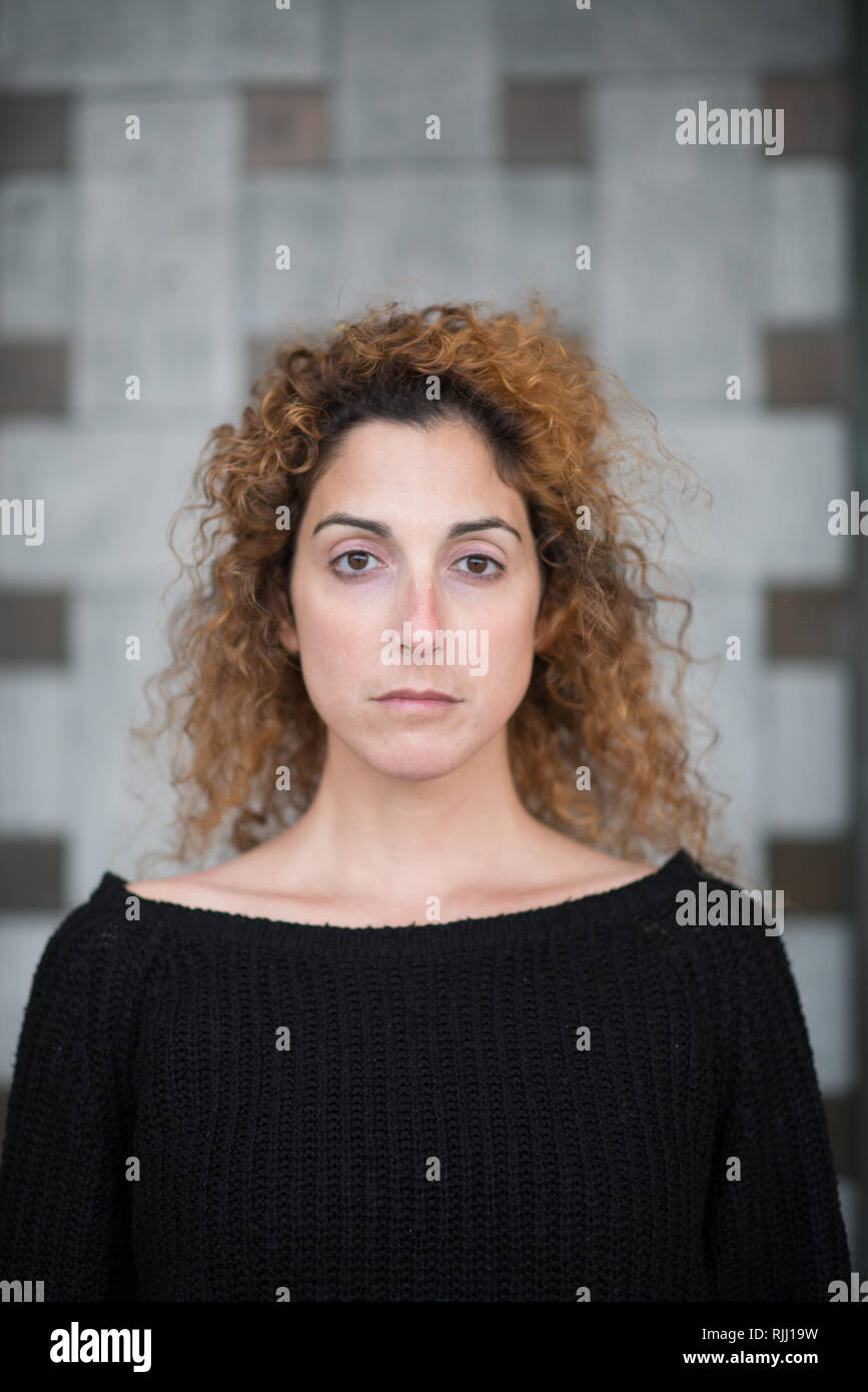 portrait of sultry beautiful woman with intense stare and curly hair ...