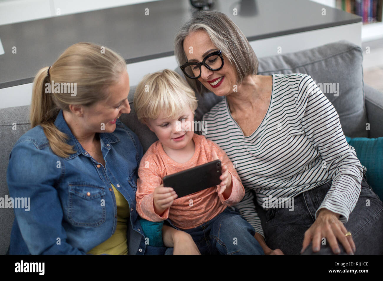 Three generations of family using a smartphone Stock Photo - Alamy