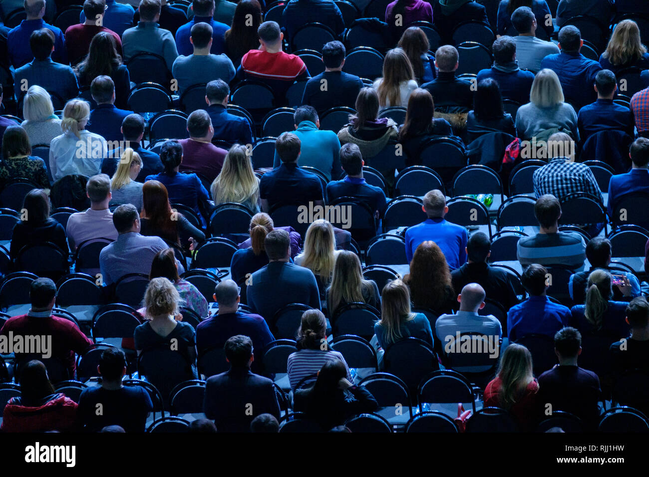 Audience listens to the lecturer at the business conference, back view ...