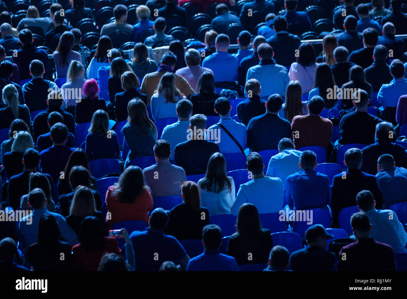 Audience listens to the lecturer at the business conference, back view ...