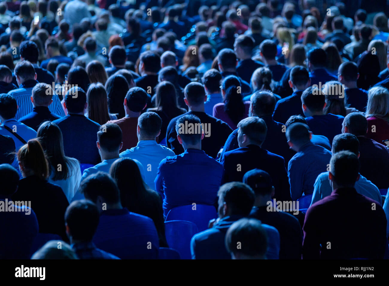 Audience listens to the lecturer at the business conference, back view ...