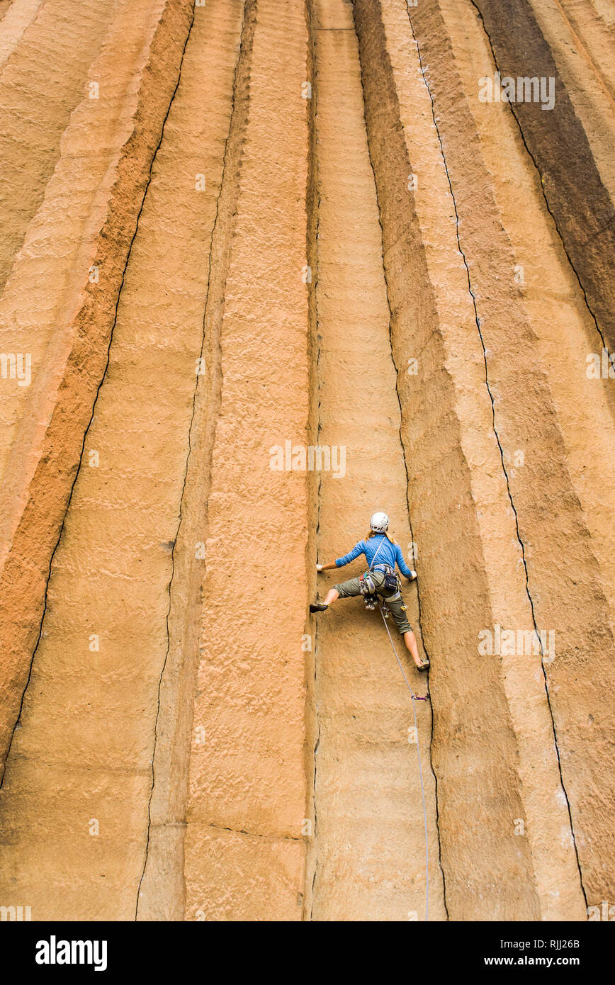 A woman lead climbing on columnar basalt rock formation at Trout Creek ...