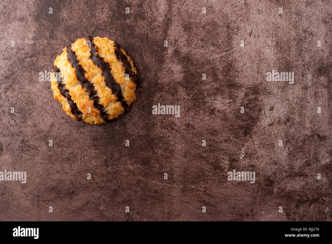 Overhead view of a single dark chocolate striped coconut macaroon ...