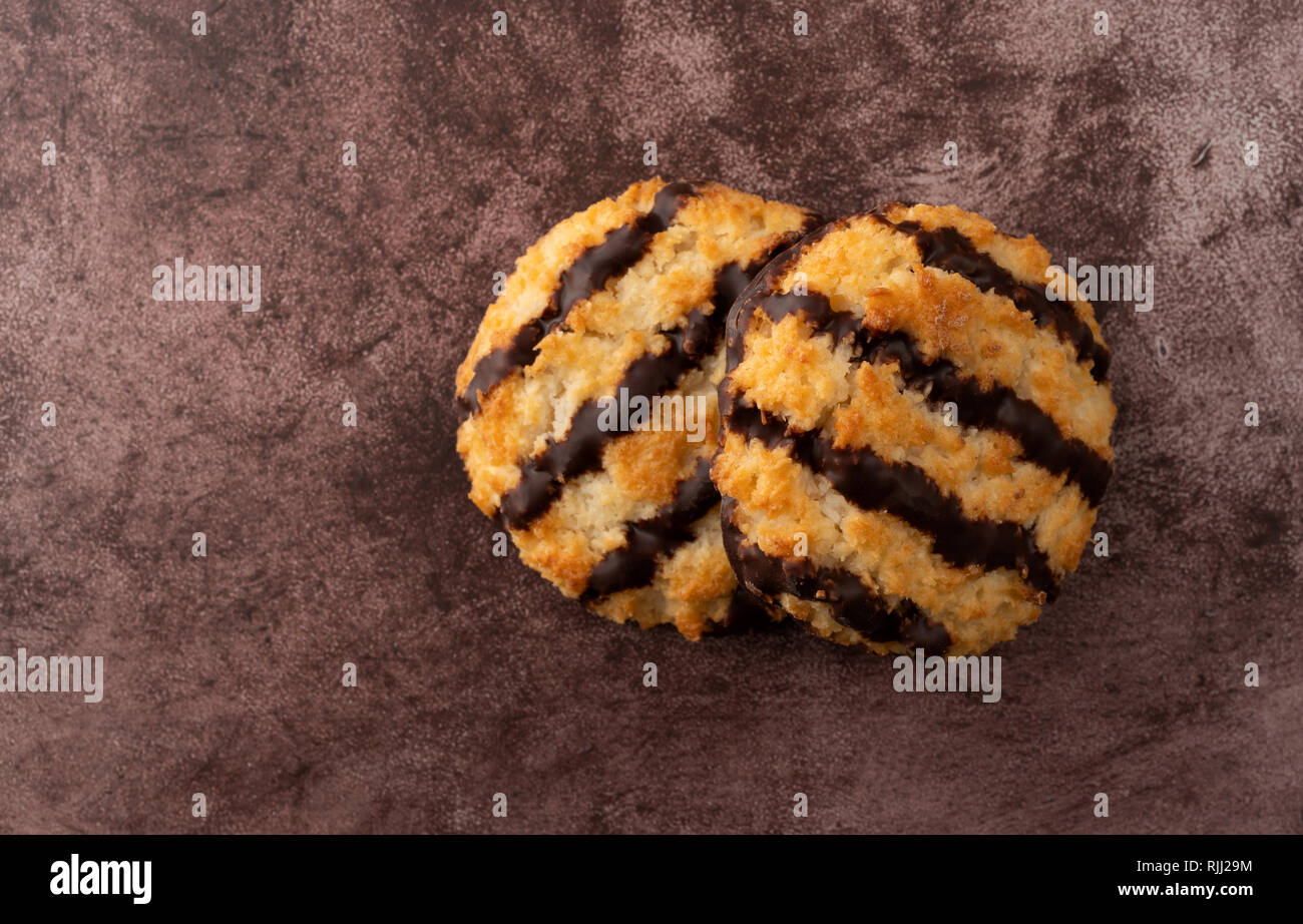 Overhead view of a two dark chocolate striped coconut macaroons on a ...