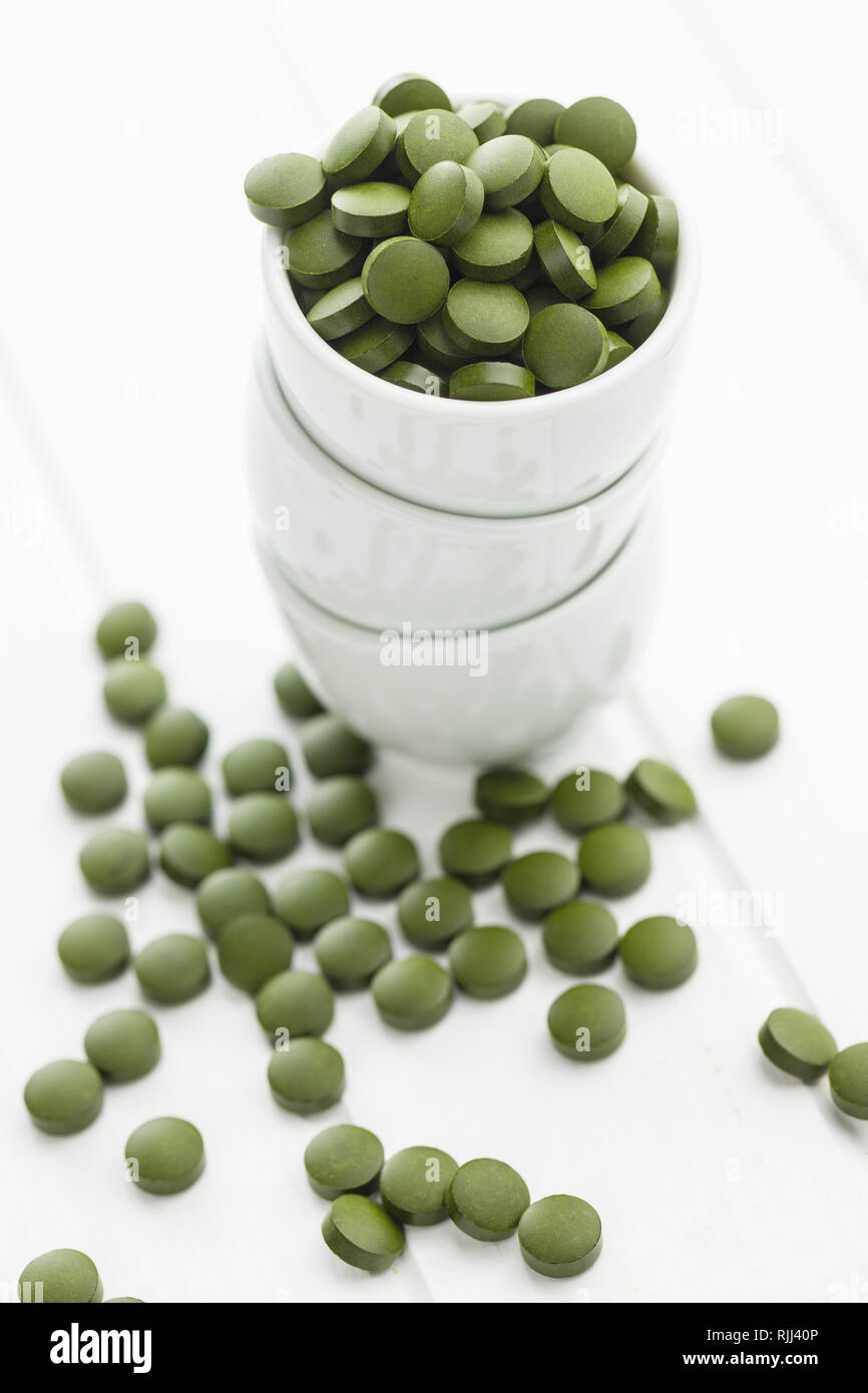 Green chlorella pills or green barley pills in bowl Stock Photo - Alamy