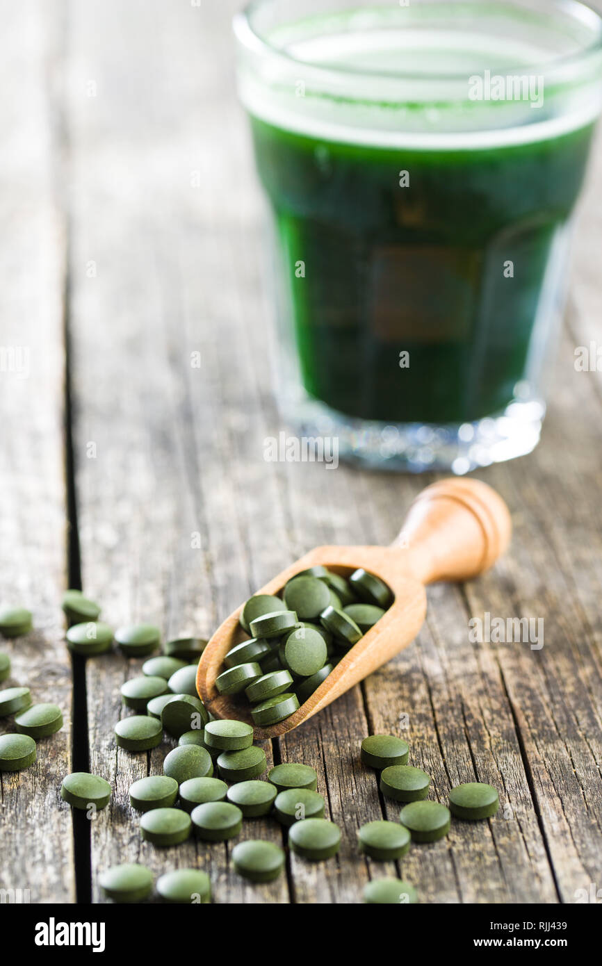 Green chlorella pills or green barley pills in wooden scoop Stock Photo ...