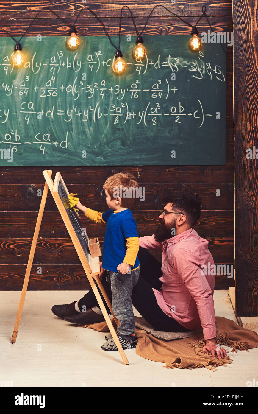 Little genius learning math. Teacher or father helping kid to solve ...