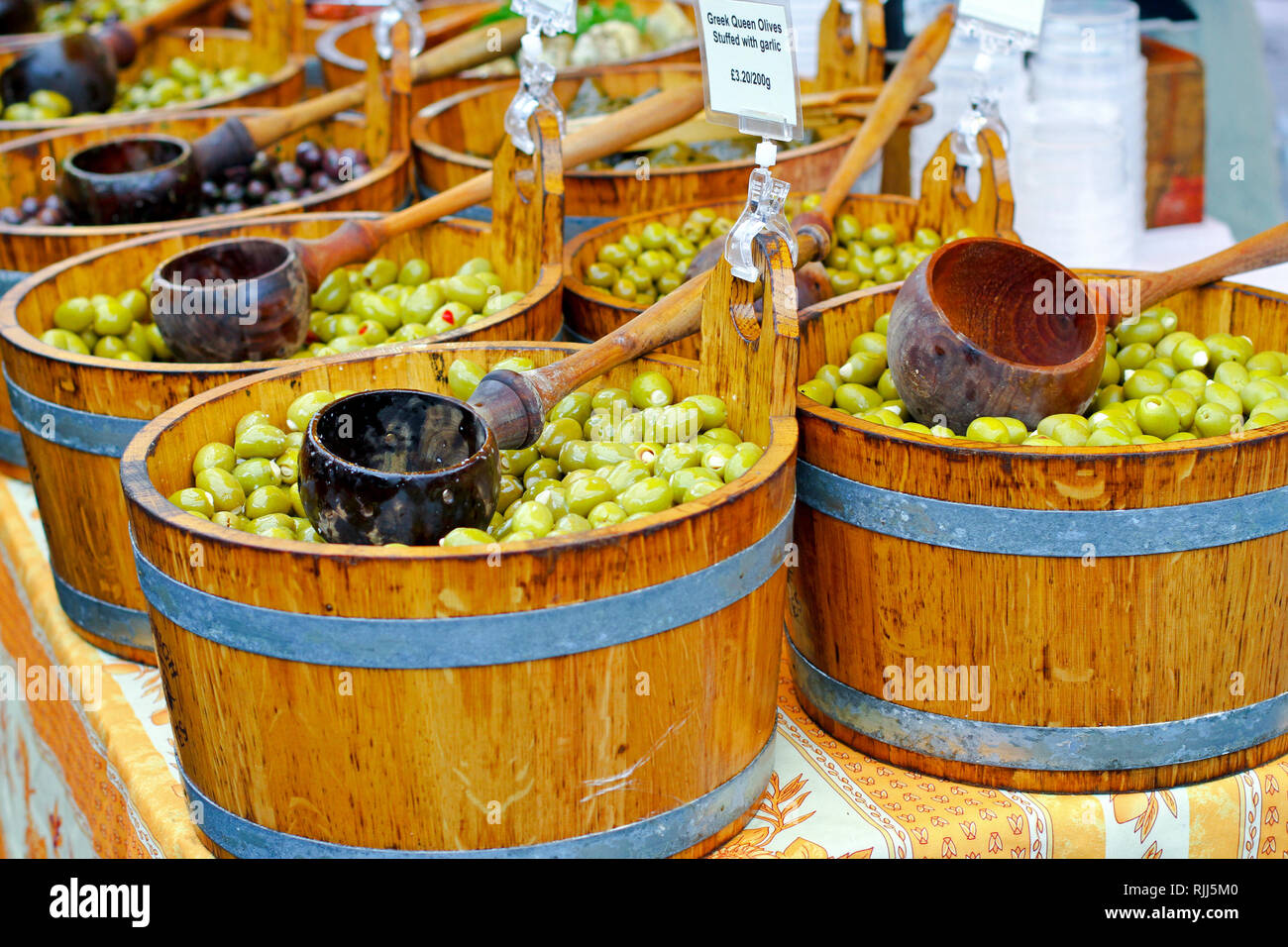 Green olives in wooden buckets sold on market Stock Photo - Alamy
