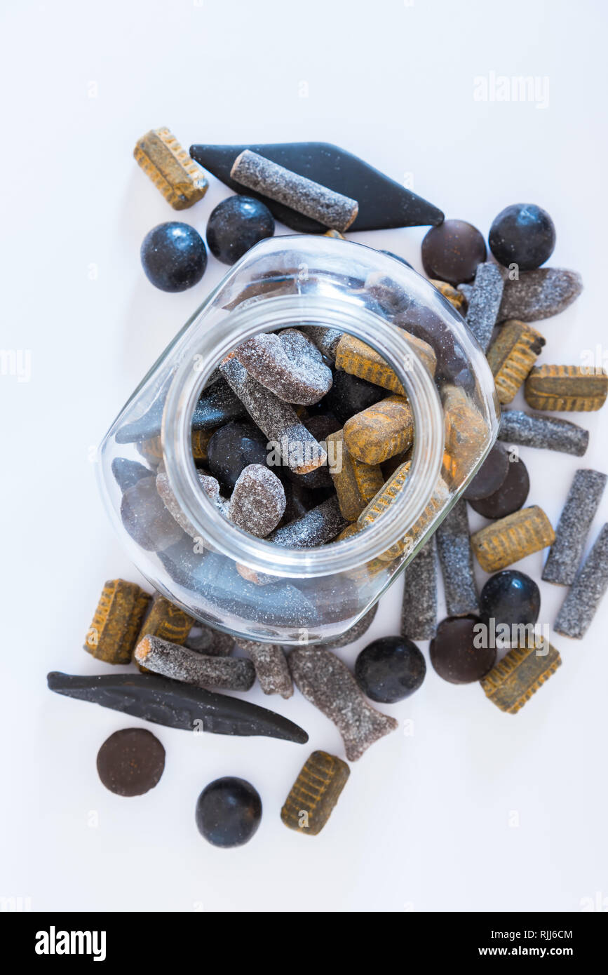 Different varieties of double salted licorice in open glass jar and on ...