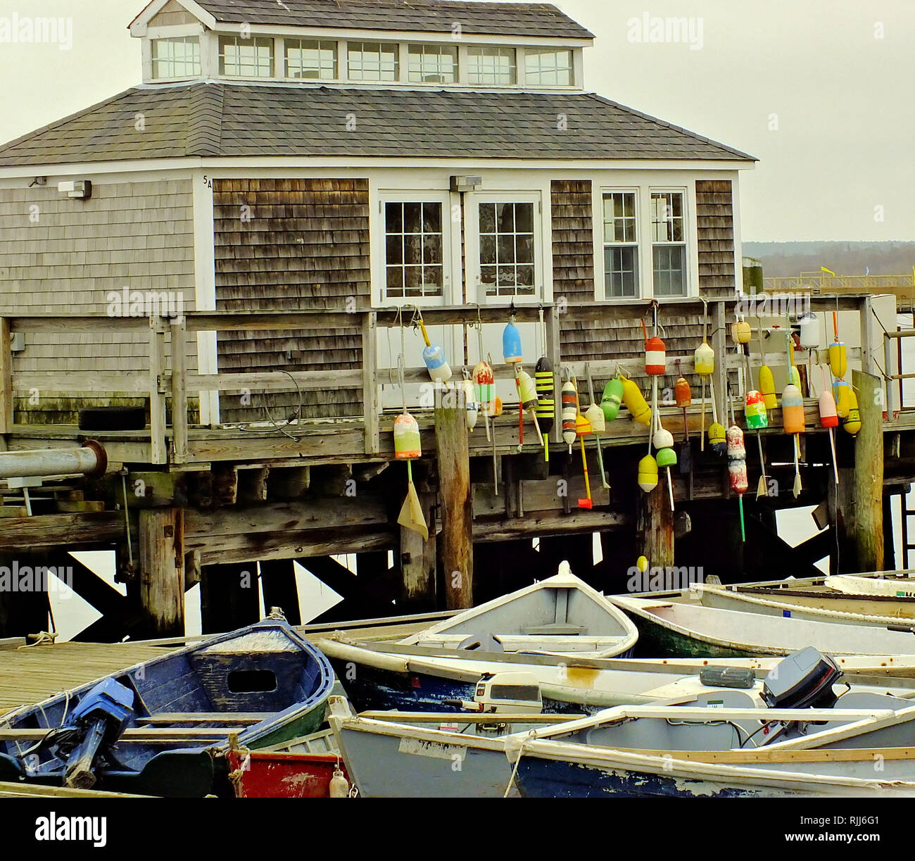 Fishing Shack with colorful buoys on the dock and boats in the ...