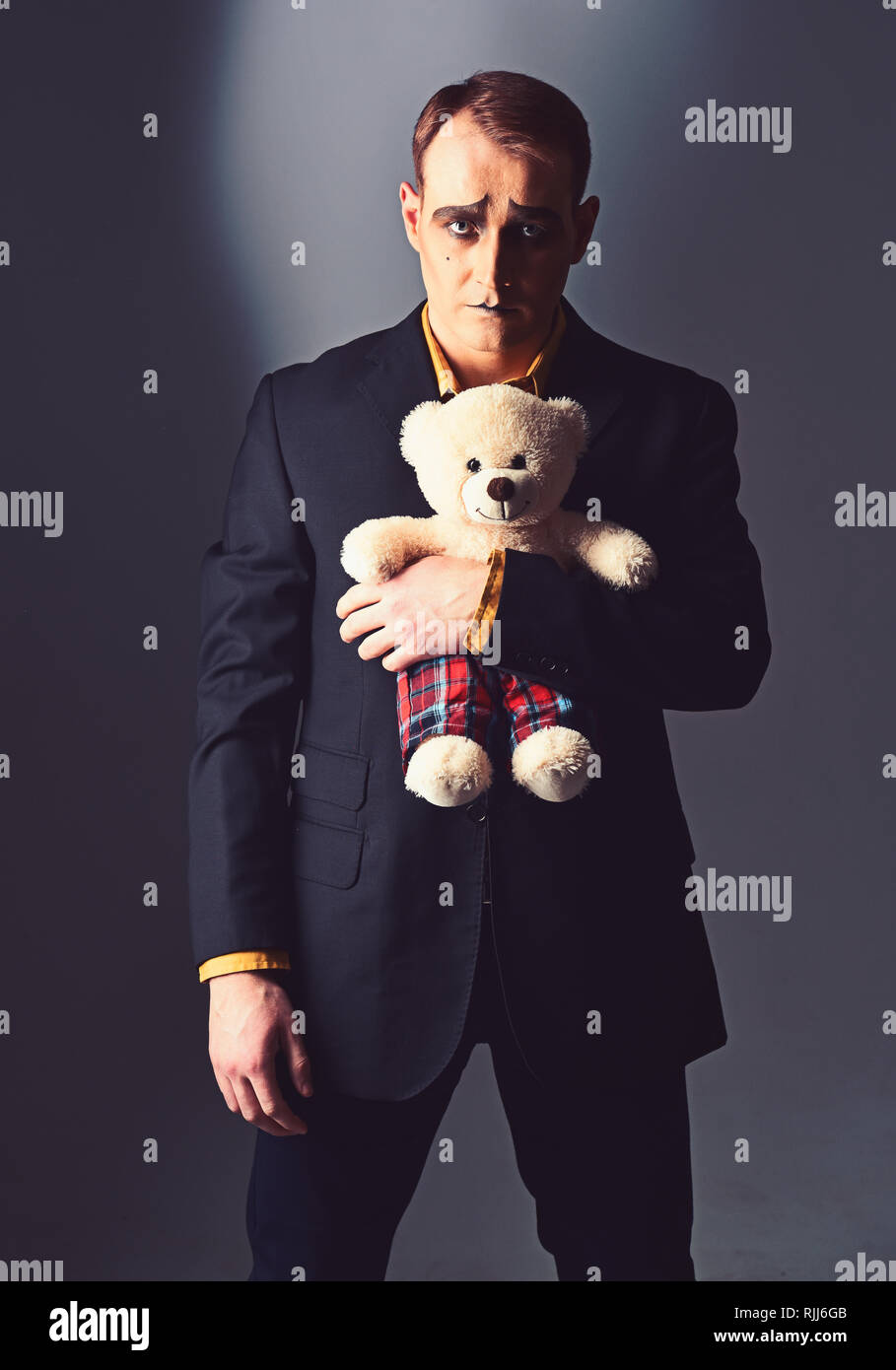 Depressed and lonely. Mime man hold teddy bear toy. Stage actor with ...