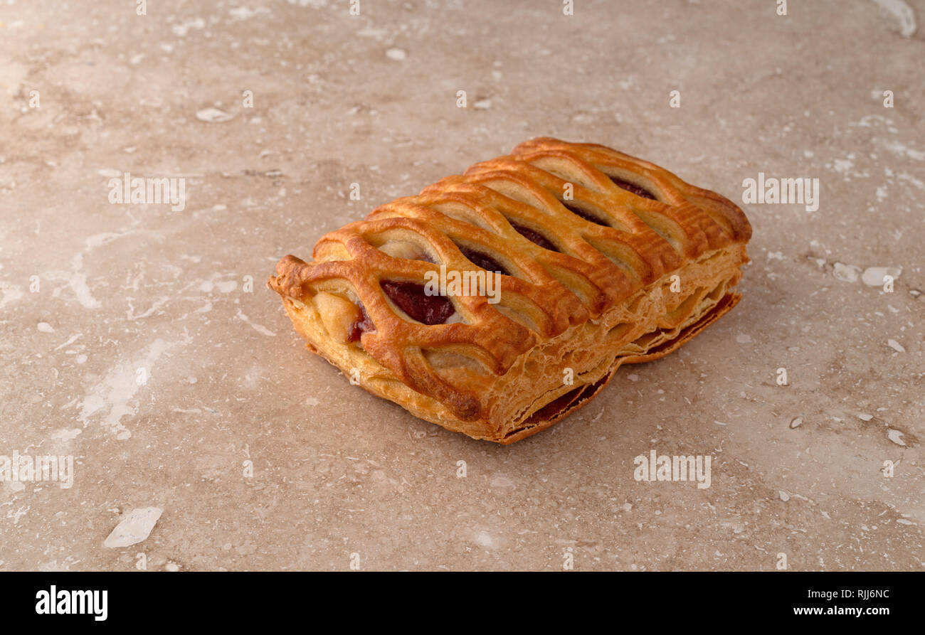 Side view of a pastry with cherry filling on a marble counter top Stock ...