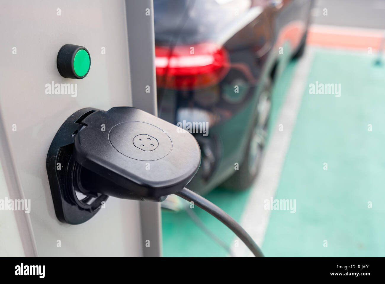 Close up of the power supply plugged into an electric car being charged ...