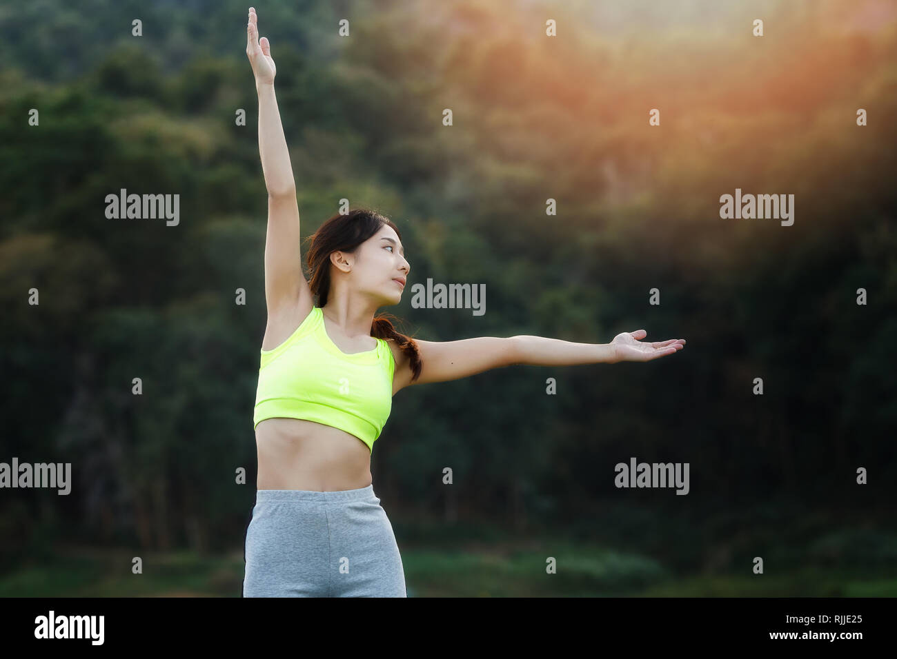 Young asian woman runner raise her hand up to resting after workout ...