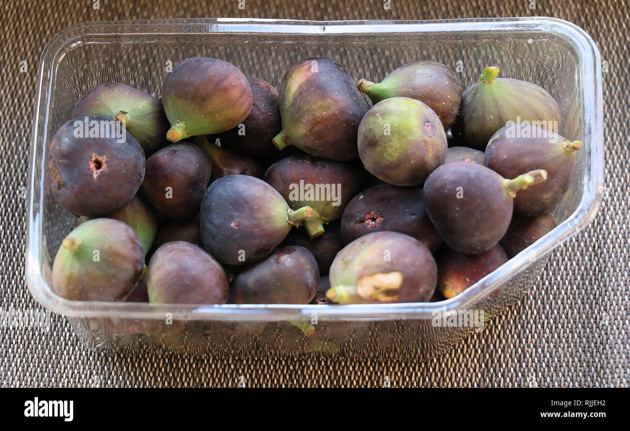 Raw organic figs fruits pile inside plastic container Stock Photo - Alamy
