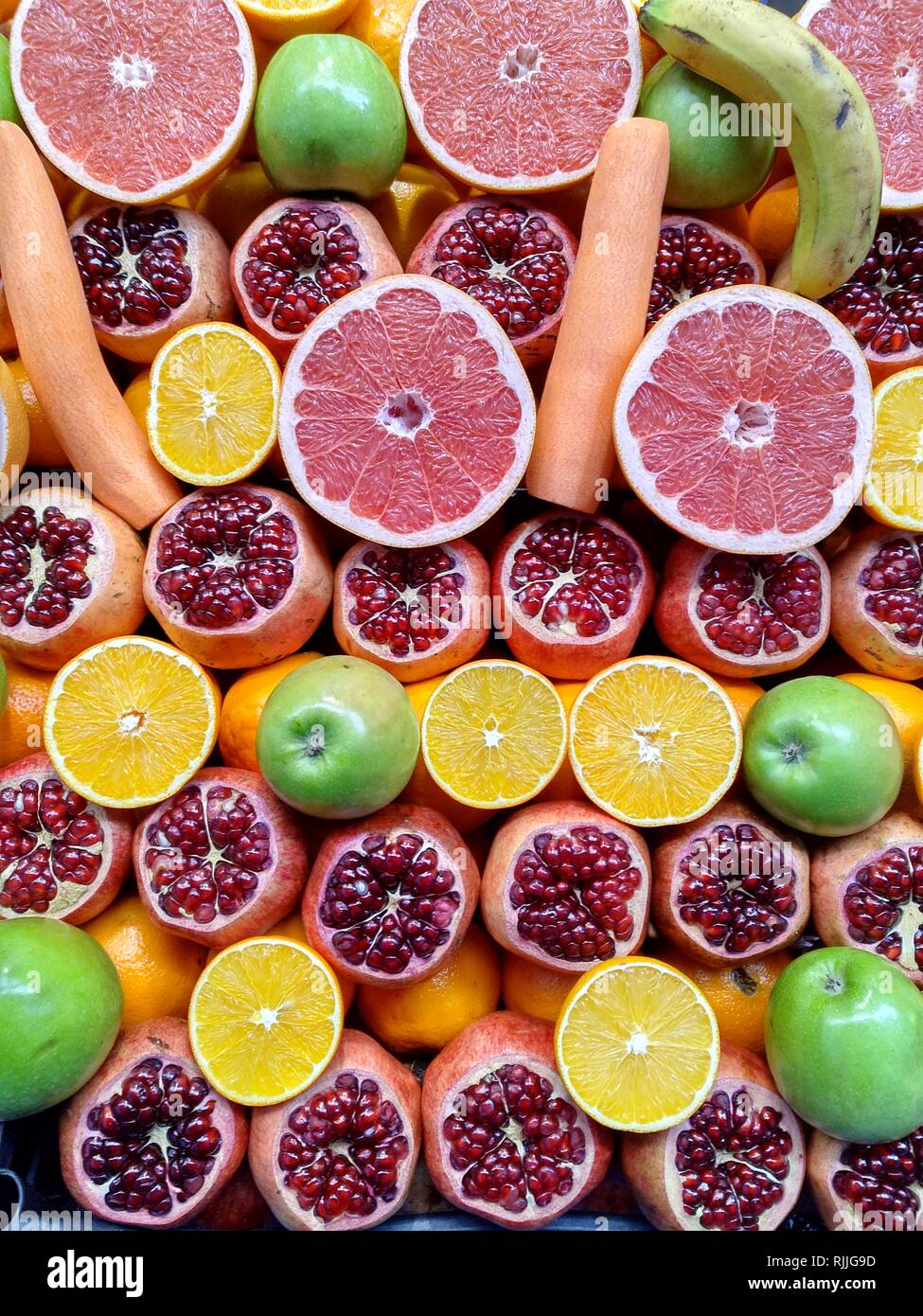 Various fruits sliced in half. Pomegranates, apples, carrots, oranges ...