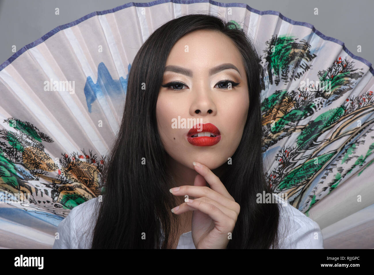 Portrait of beautiful young asian woman with fan on background Stock ...