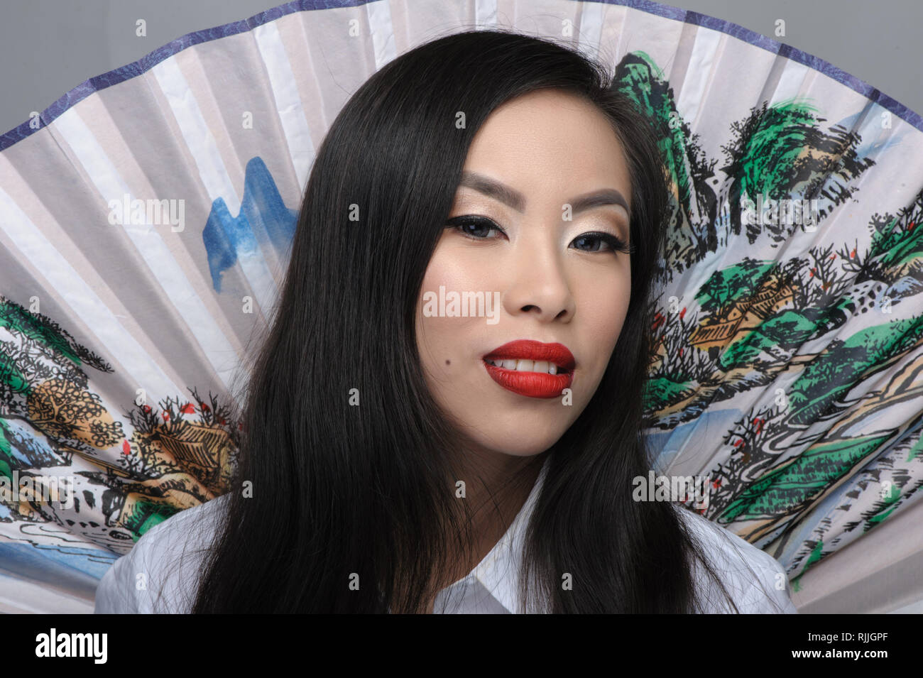 Portrait of beautiful young asian woman with fan on background Stock ...