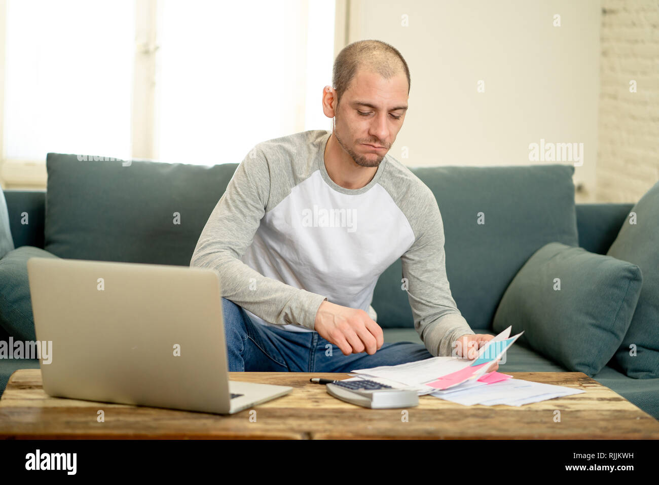 Young attractive caucasian creative self employed man accounting costs ...
