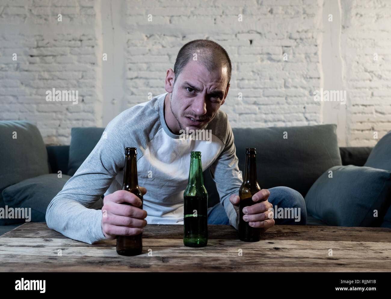 Young sad drunk men drinking beer and alcohol feeling wasted, lonely ...