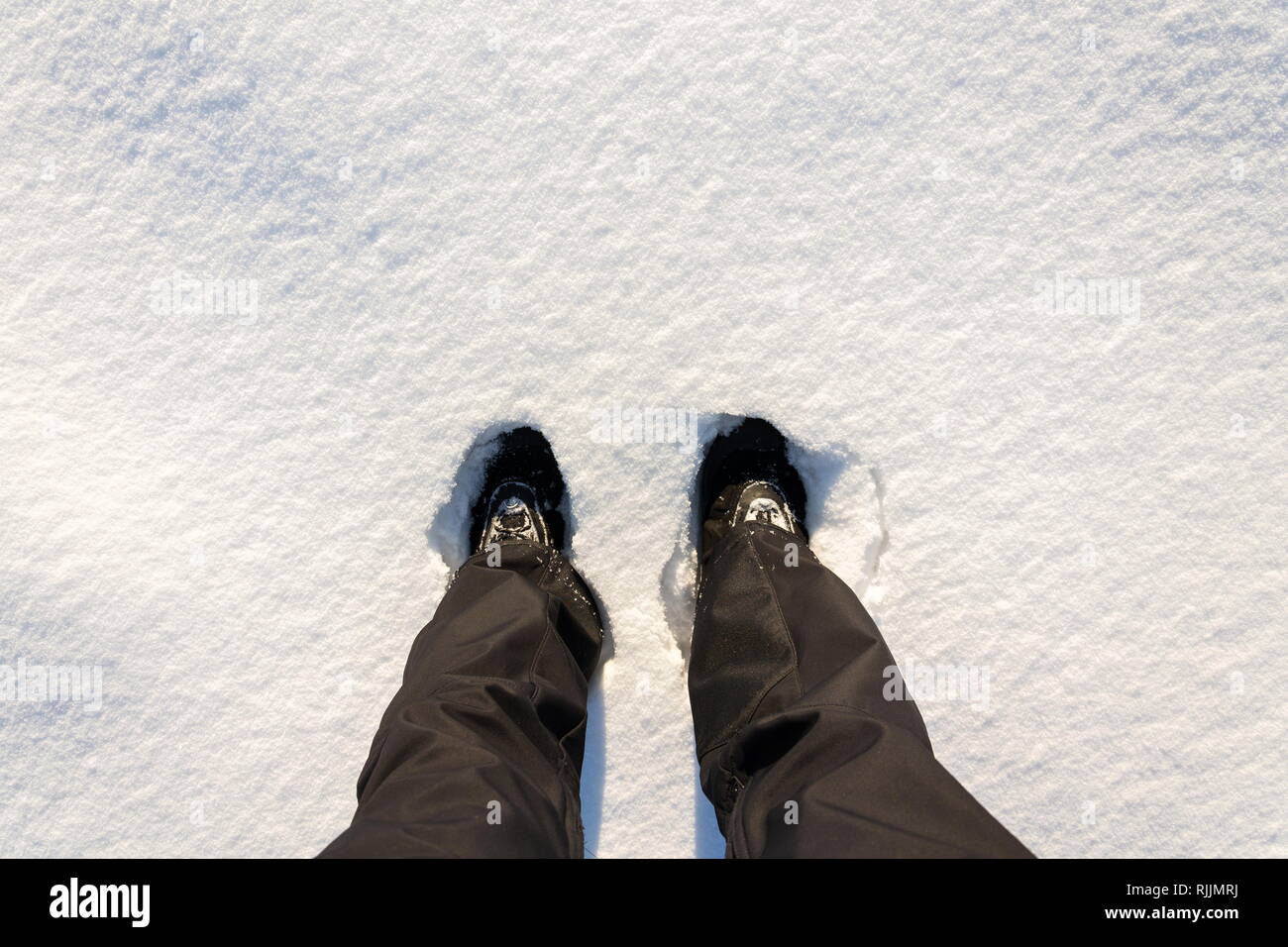 Top flat lay view of feet in waterproof winter boots in fresh snow ...