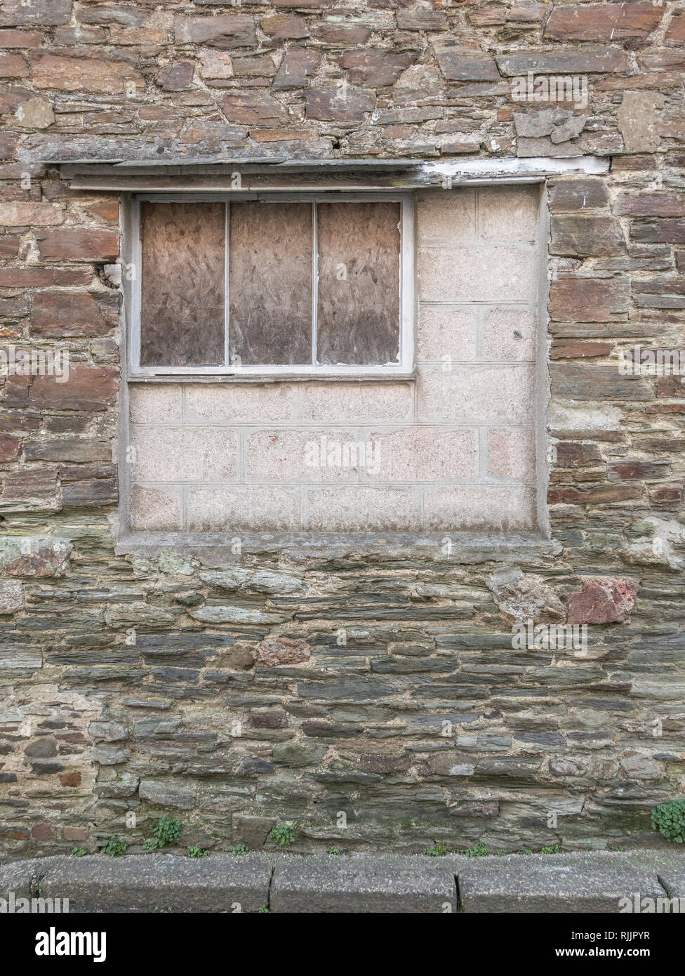 Partially bricked-up window in an outhouse building Stock Photo - Alamy