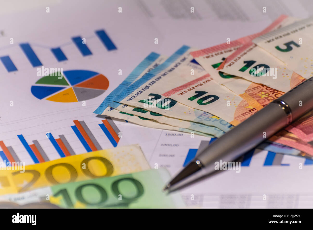 Business diagram on financial report with bills and pen Stock Photo - Alamy