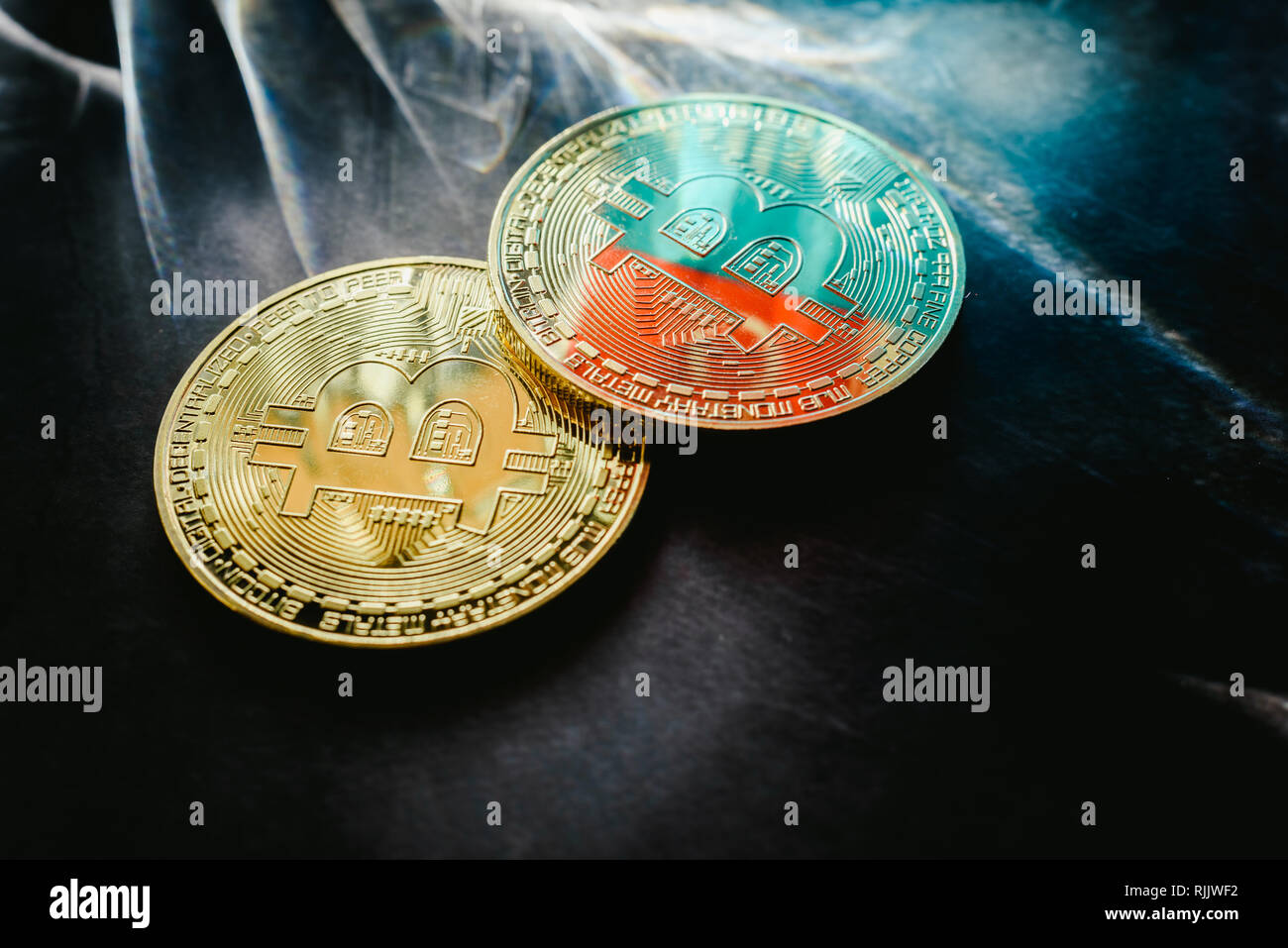 Bitcoin physical coins illuminated by light rays with dark background ...