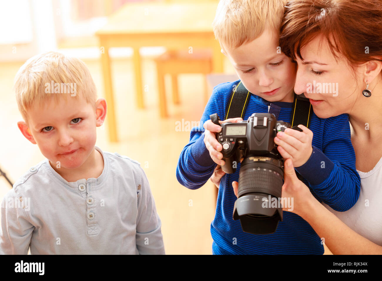 Happy childhood. Mother and her sons boys children playing with camera ...