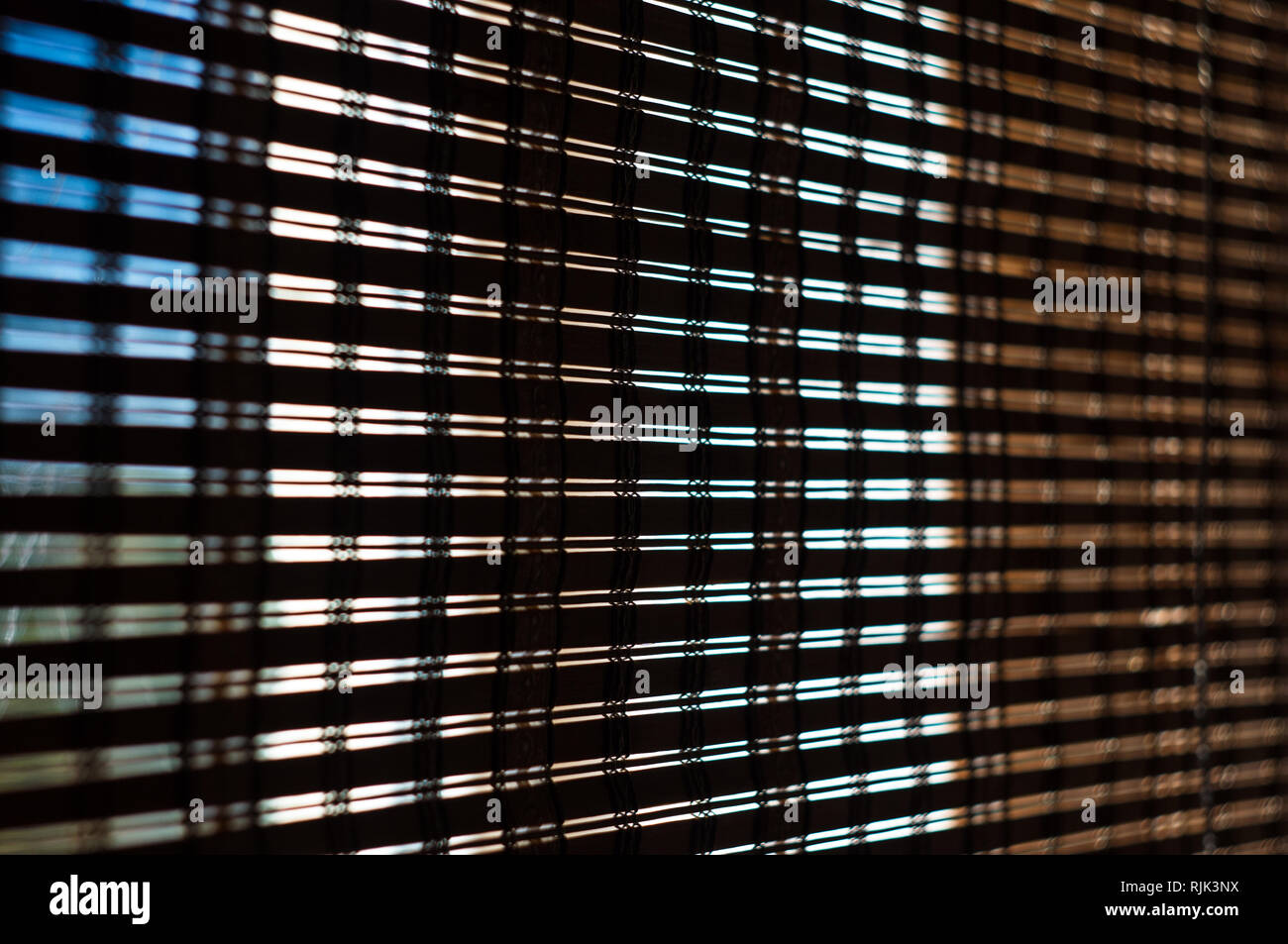 The interior of the home, sunlight shining through the bamboo blinds at ...
