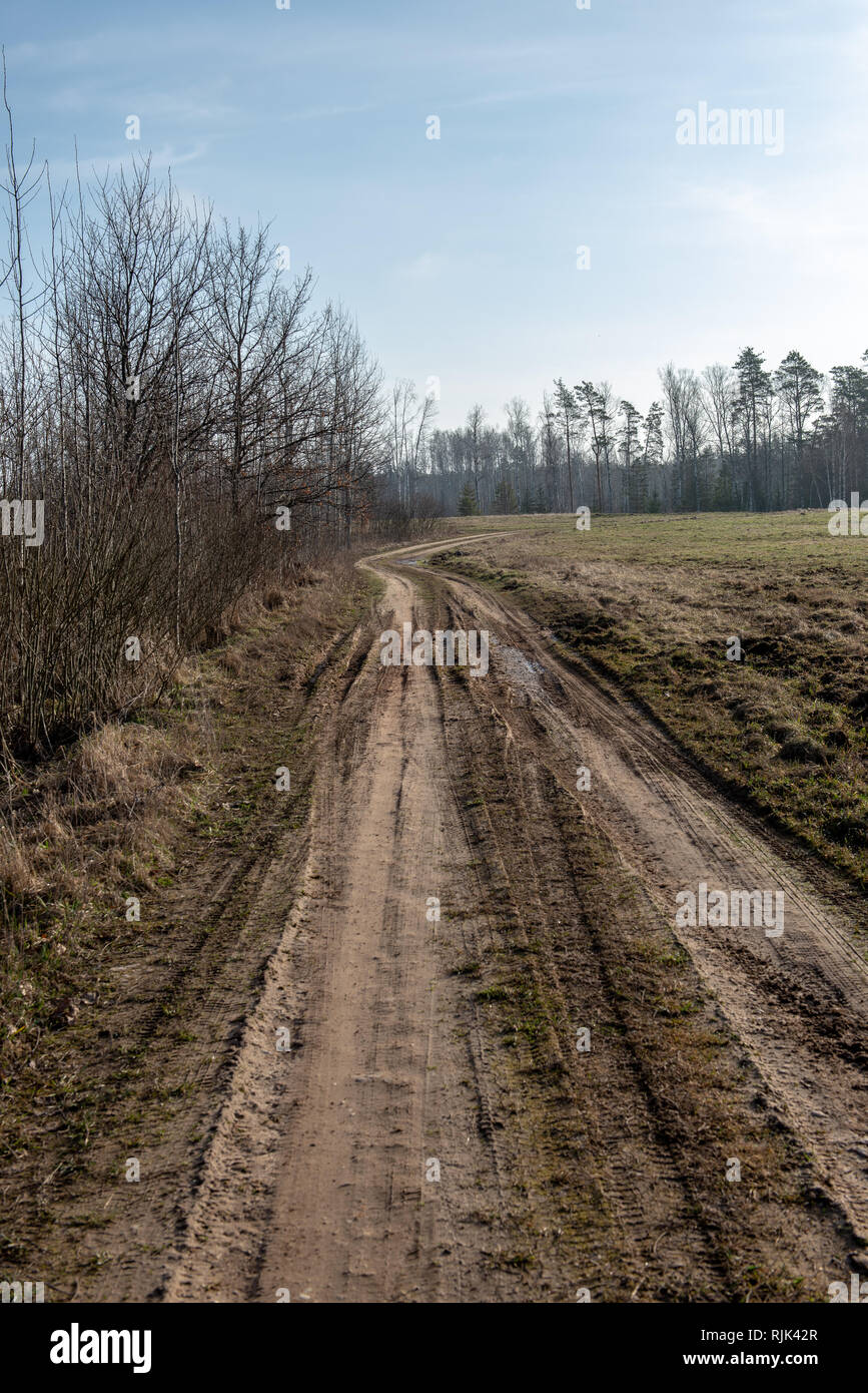 empty country gravel road with mud puddles and bumps. dirty road ...
