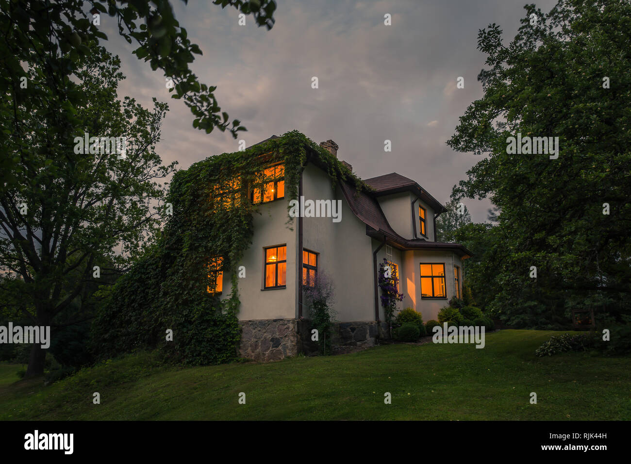 Romantic house with a light in the window. Night landscape Stock Photo ...