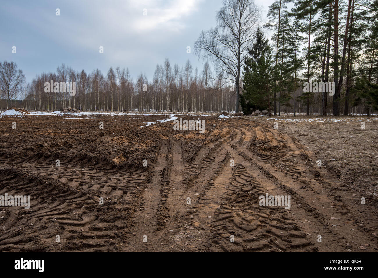 empty country gravel road with mud puddles and bumps. dirty road surface with sand and small ...
