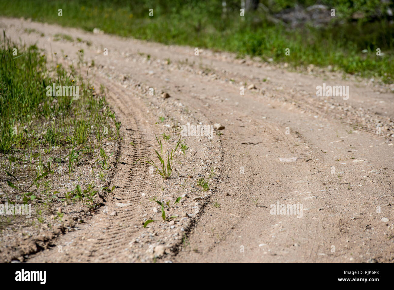 empty country gravel road with mud puddles and bumps. dirty road surface with sand and small ...