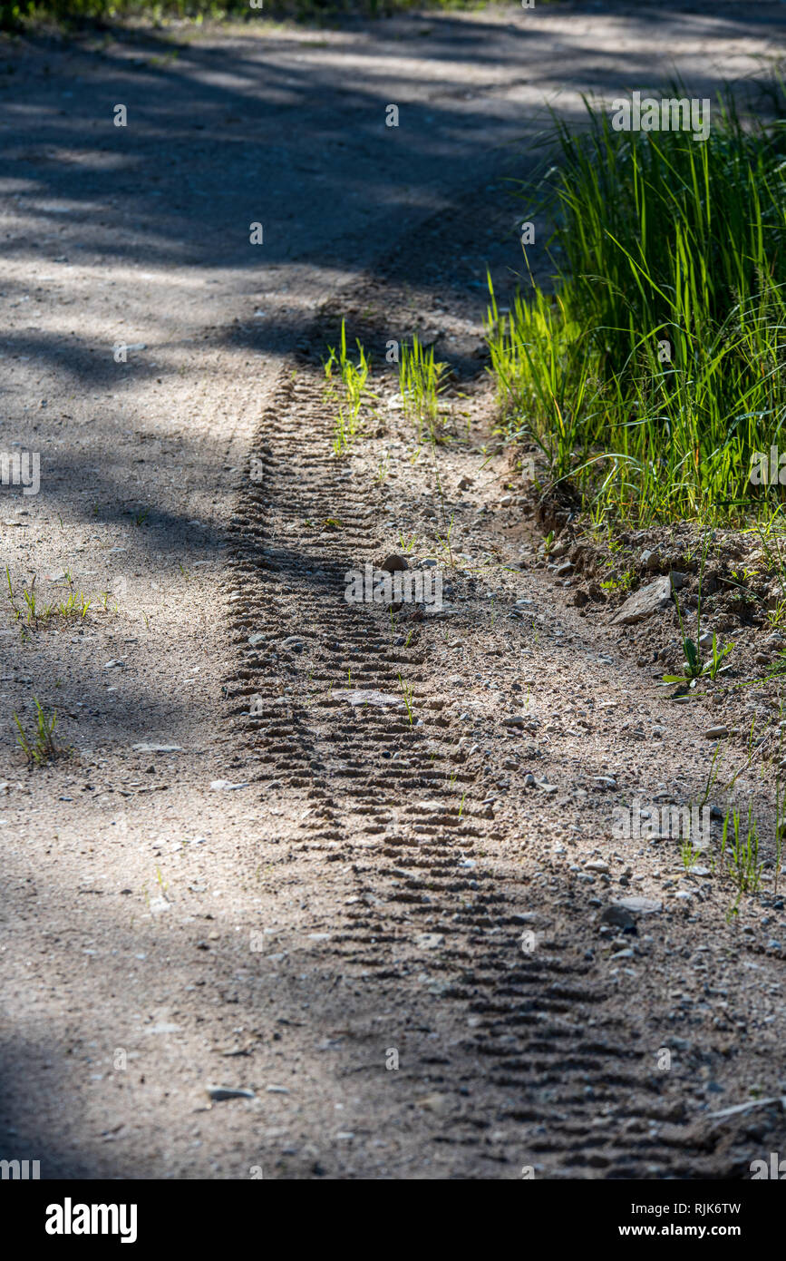 empty country gravel road with mud puddles and bumps. dirty road surface with sand and small ...