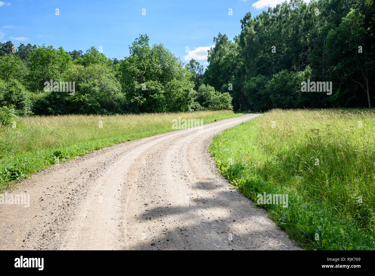 empty country gravel road with mud puddles and bumps. dirty road surface with sand and small ...