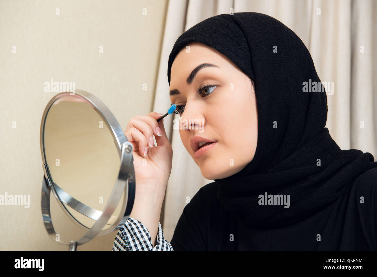 Beauty muslim woman with hijab applying makeup. Beautiful girl looking ...