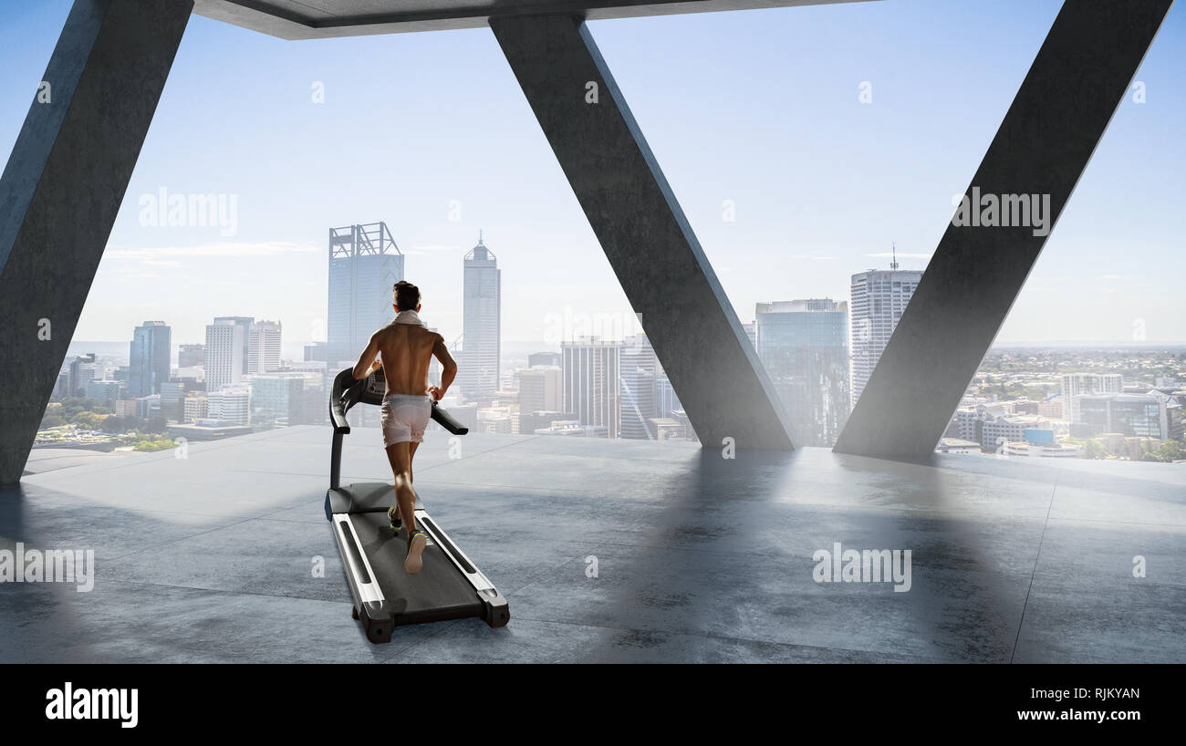 Back view of man athlete running on treadmill. Mixed media Stock Photo ...