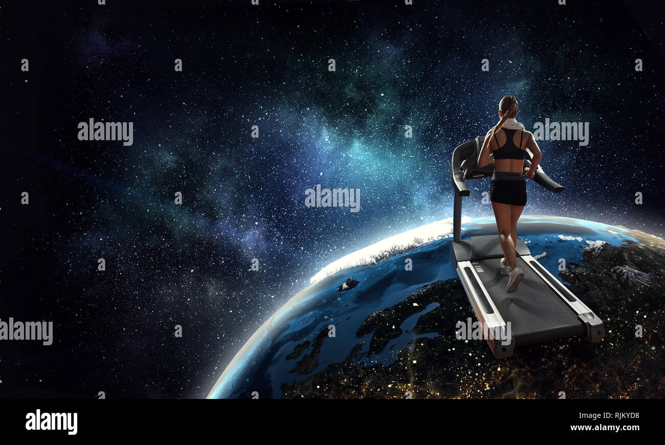 Back view of pretty young woman athlete running on treadmill. Mixed ...