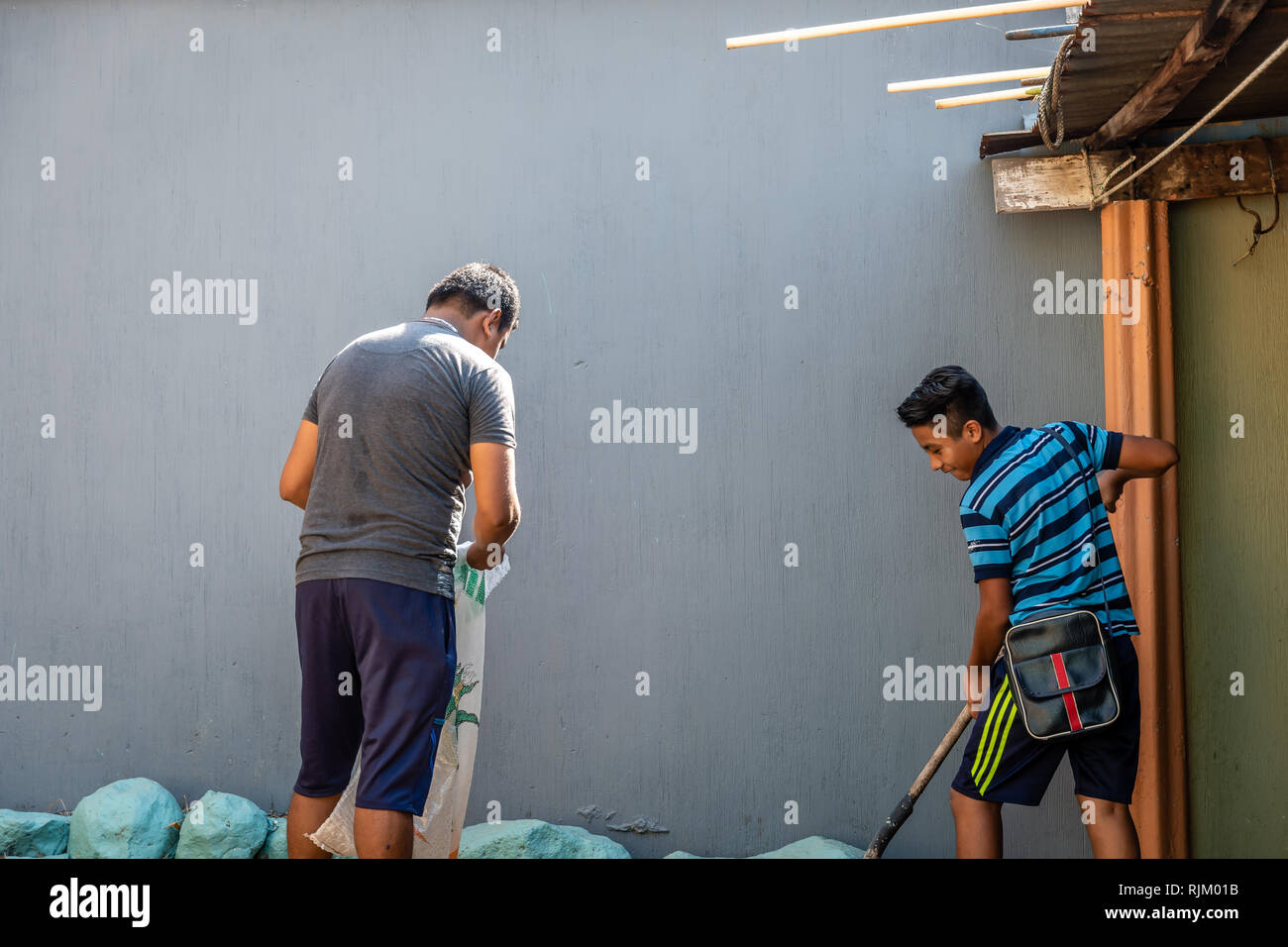 latin man and boy shoveling dirt in Guatemala Stock Photo - Alamy
