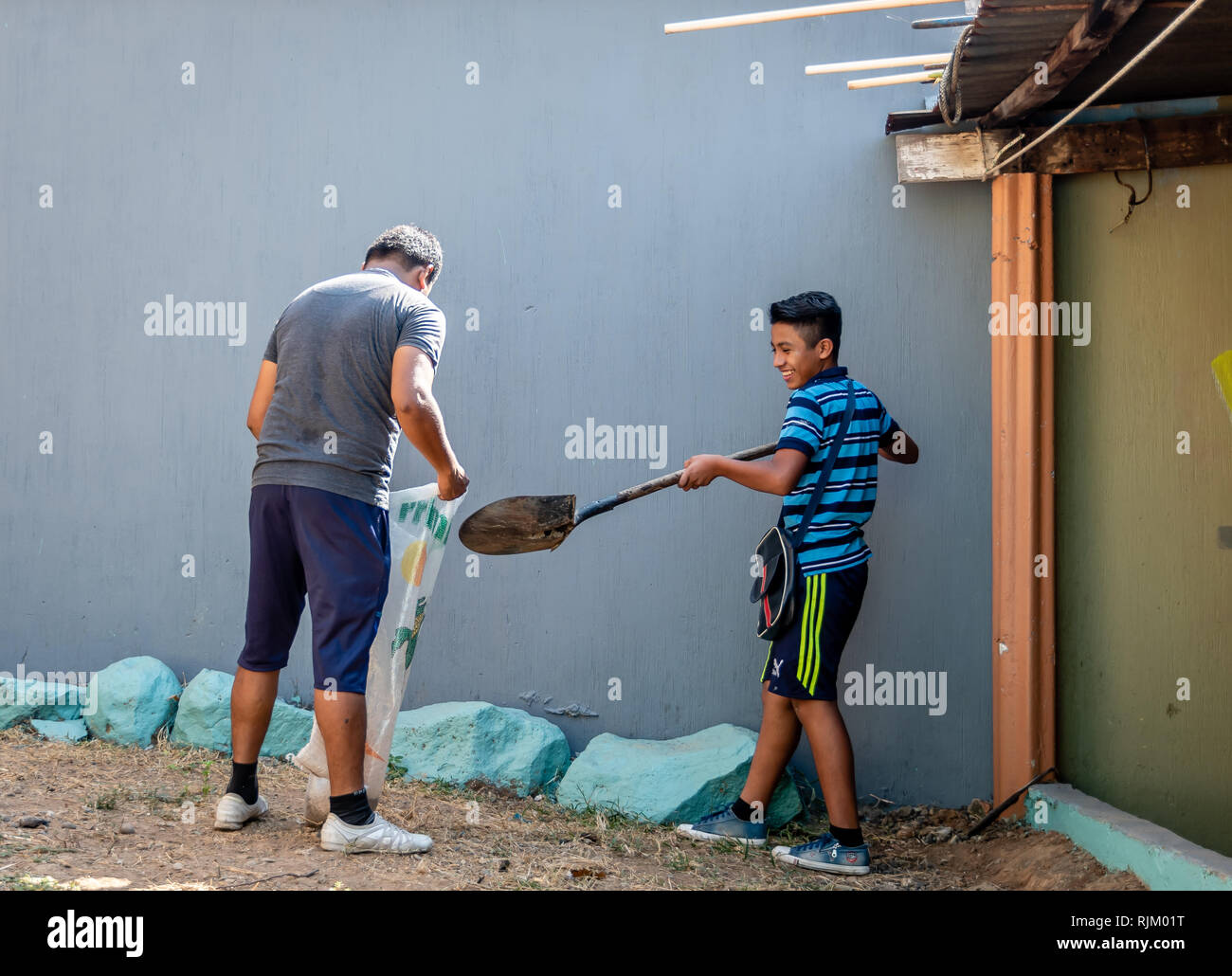 latin man and boy shoveling dirt in Guatemala Stock Photo - Alamy